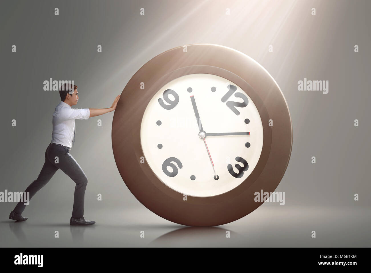 Young asian businessman pushing analog clock with bright background ...
