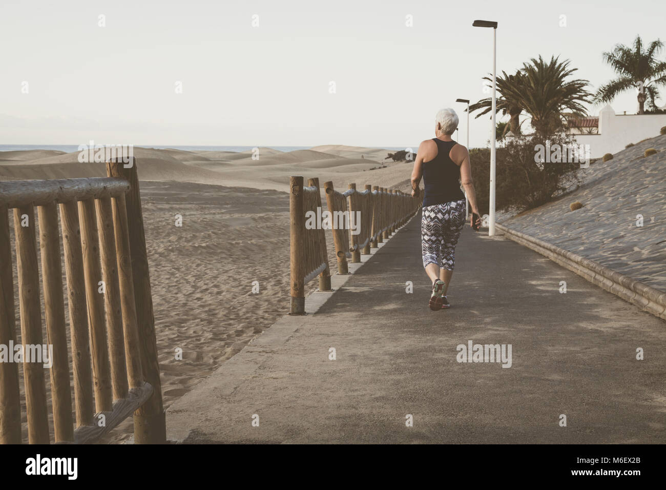 Walkers and runners on seaside promenade in Maspalomas, Gran Canaria ...