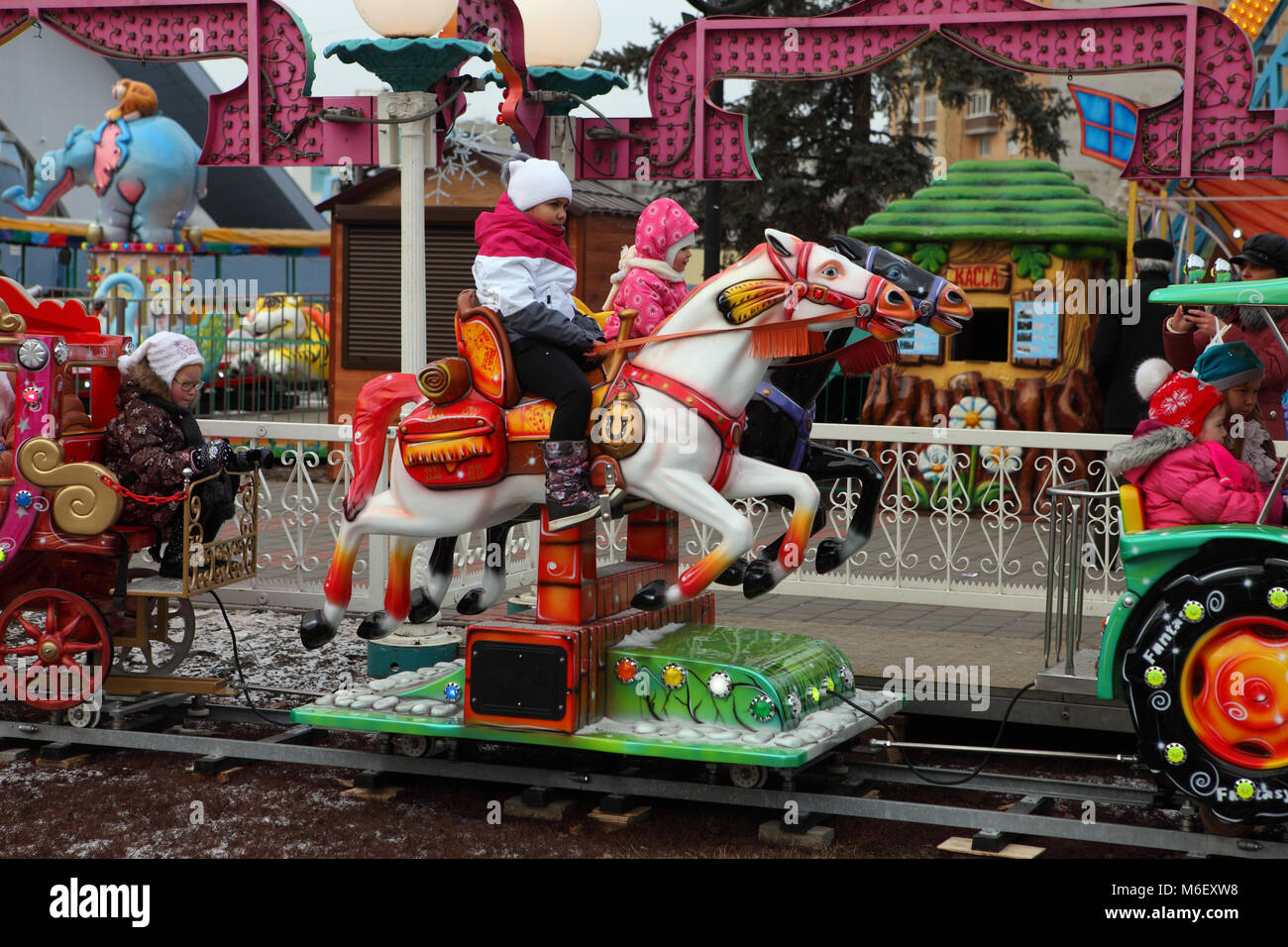 Happy little kid riding park carousel horse Stock Photo - Alamy