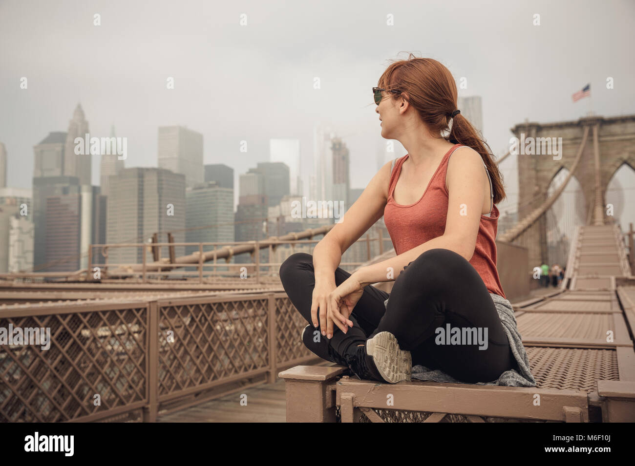 Woman sitting on the Brooklyn bridge and looking the view Stock Photo ...
