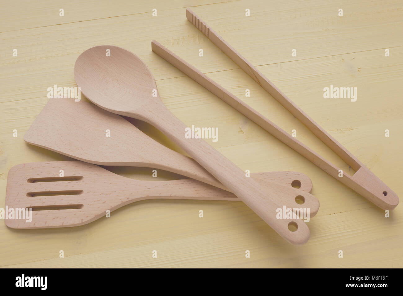 A group of wooden kitchen utensils on yellow work surface Stock Photo ...