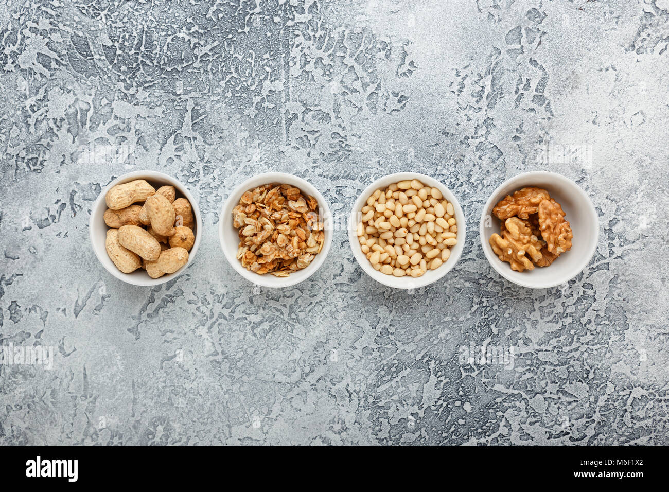 Set of different types of nuts - peanuts in shells, pine nuts on gray ...