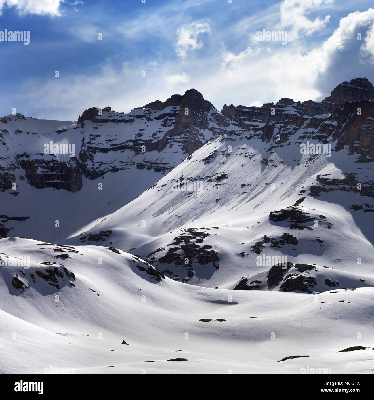 Rocks in snow and blue sky with clouds at windy day. Turkey, Central ...