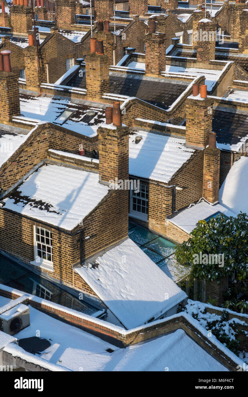 Rows of terraced homes or houses with their rooftops covered in snow ...