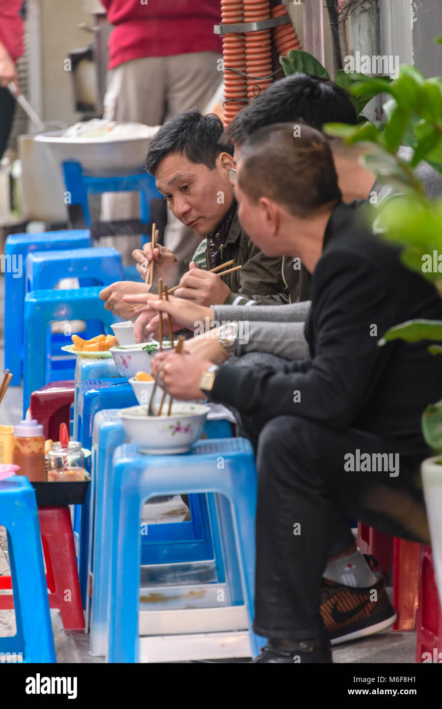 Men eat street food breakfast on the footpath in Hanoi, Vietnam Stock ...