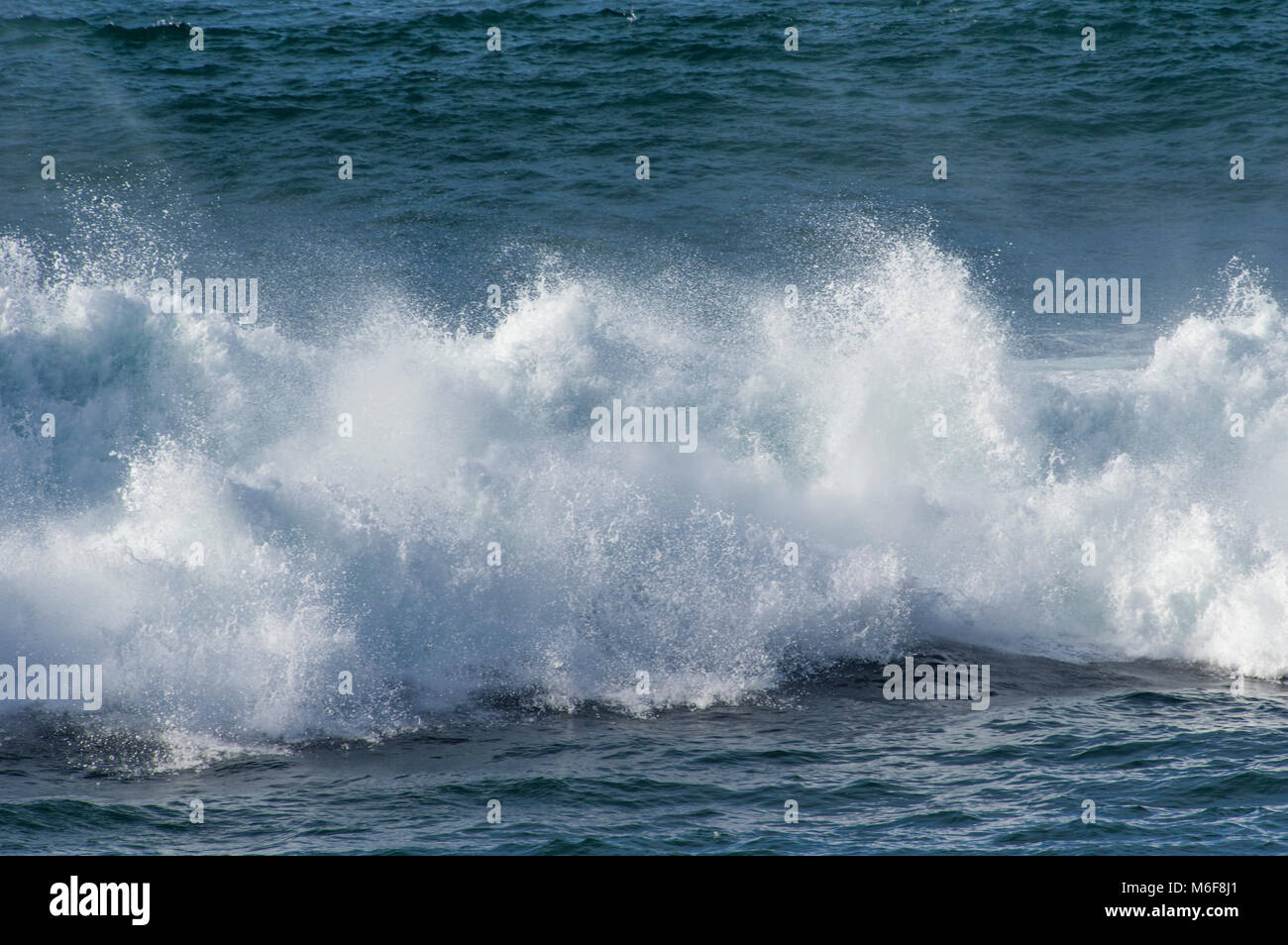 White water surf and froth from a breaking wave head toward the shore ...