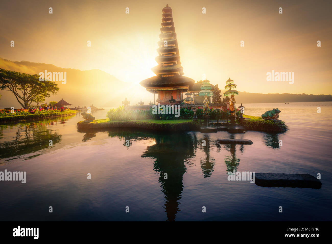 Pura Ulun Danu Bratan, Hindu temple on Bratan lake landscape with lens flare at sunrise in Bali ...