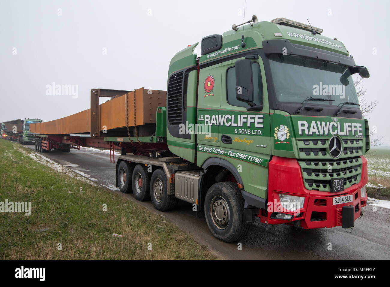 Heavy haulage trucks carrying metal for bridge construction for the ...