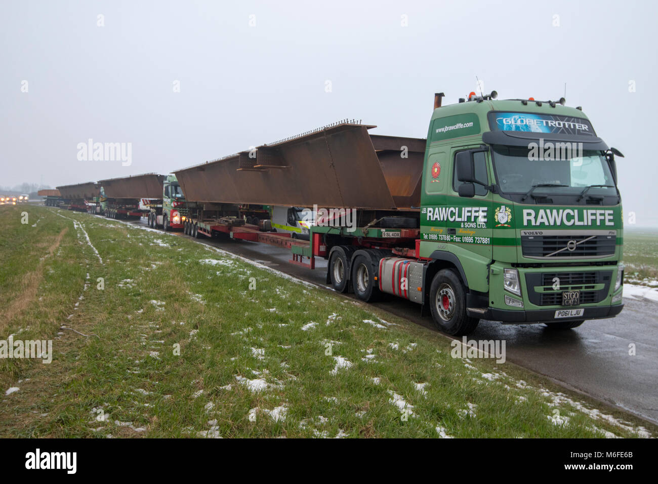 Heavy haulage trucks carrying metal for bridge construction for the ...