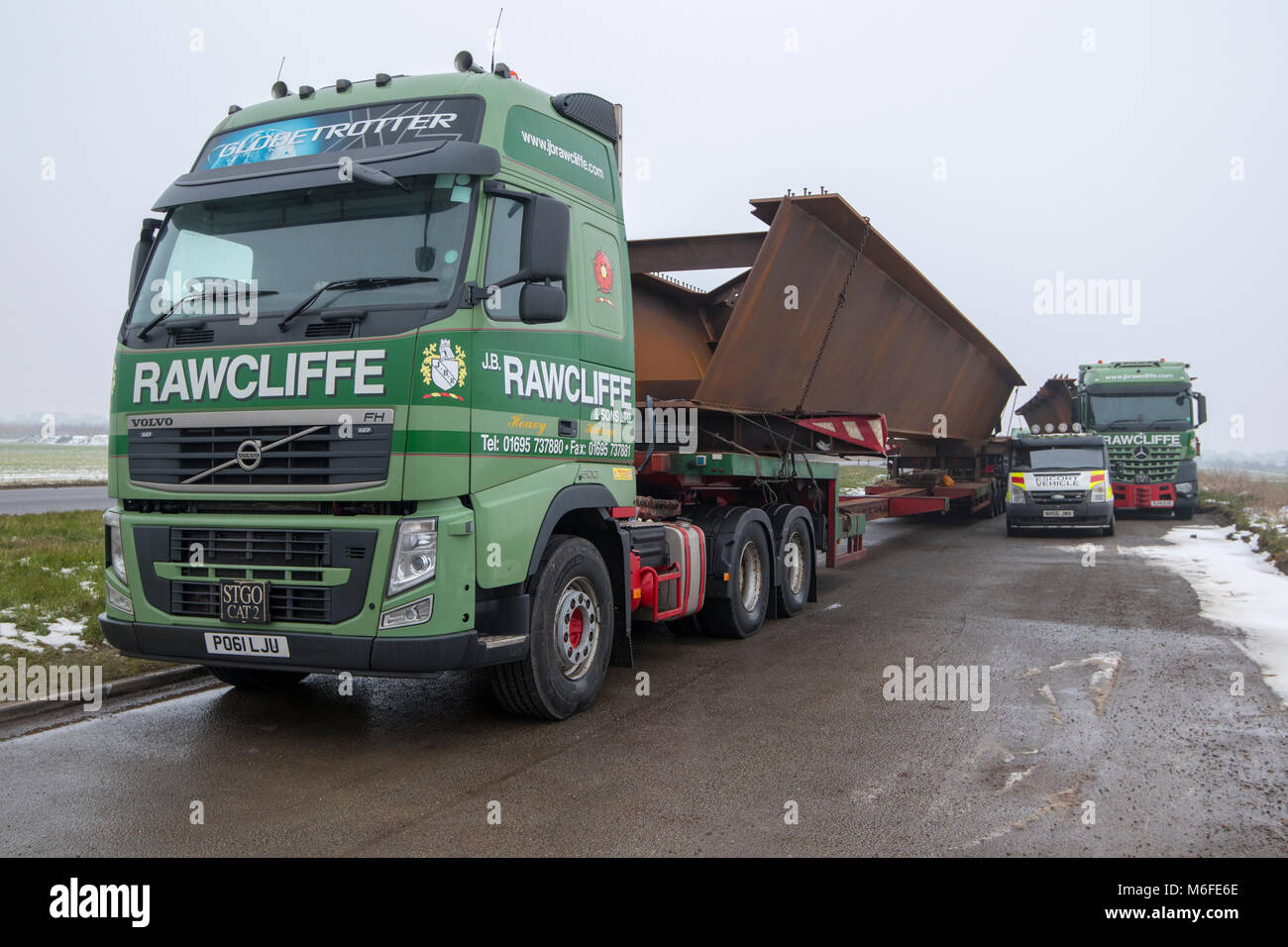 Heavy haulage trucks carrying metal for bridge construction for the ...