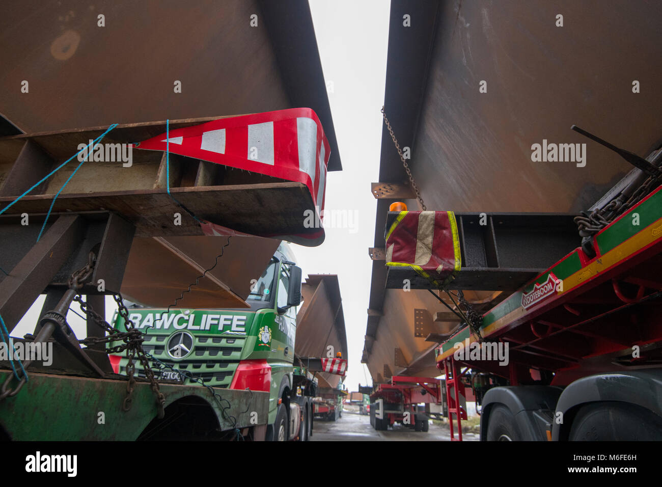 Heavy haulage trucks carrying metal for bridge construction for the ...