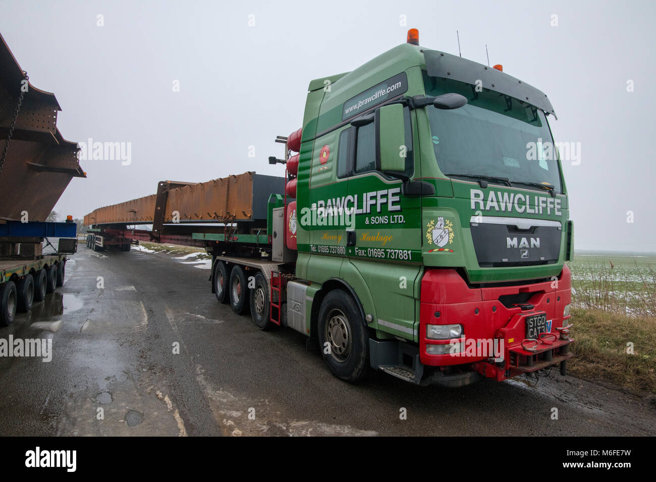 Heavy haulage trucks carrying metal for bridge construction for the ...