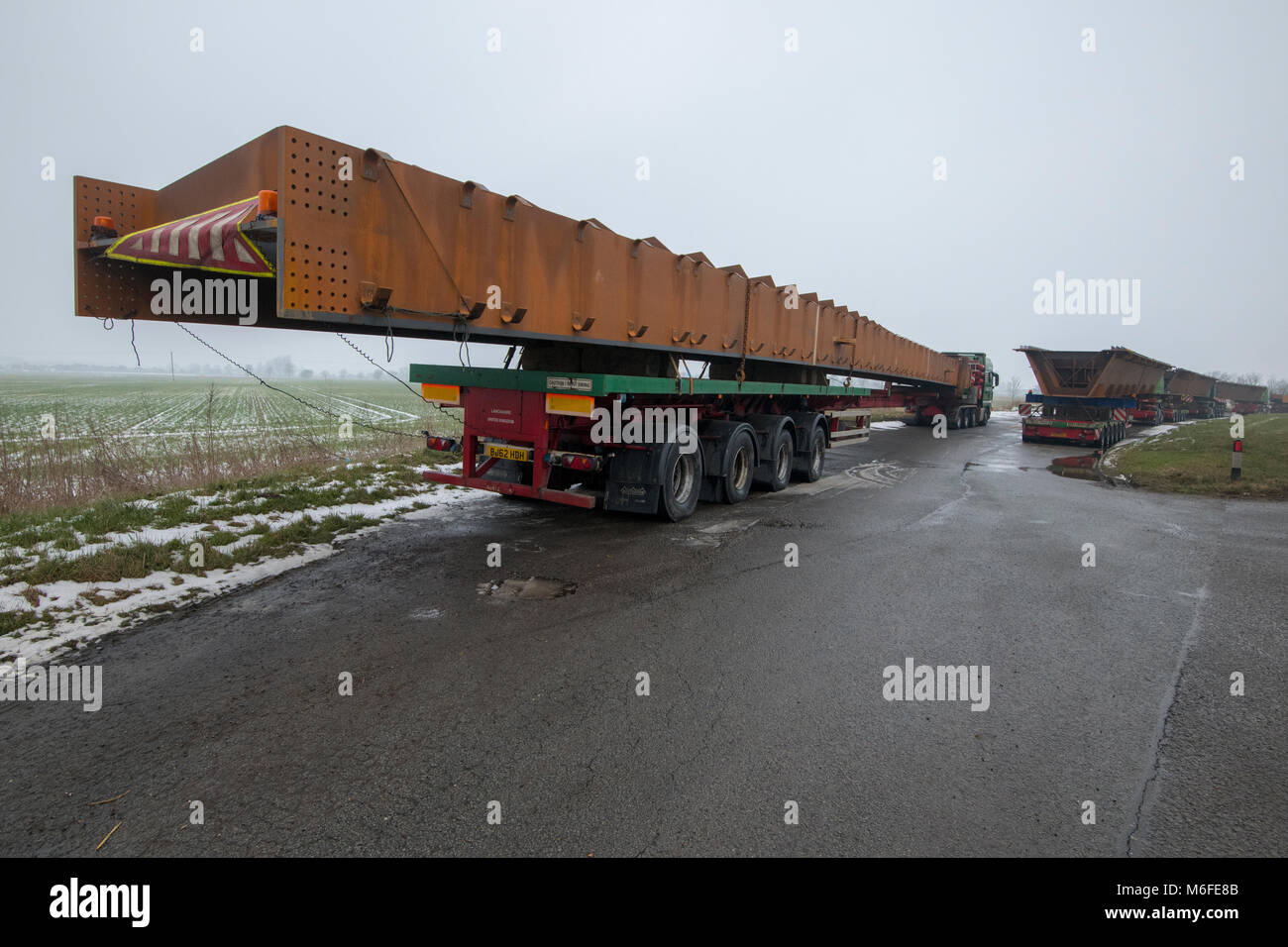 Heavy haulage trucks carrying metal for bridge construction for the ...