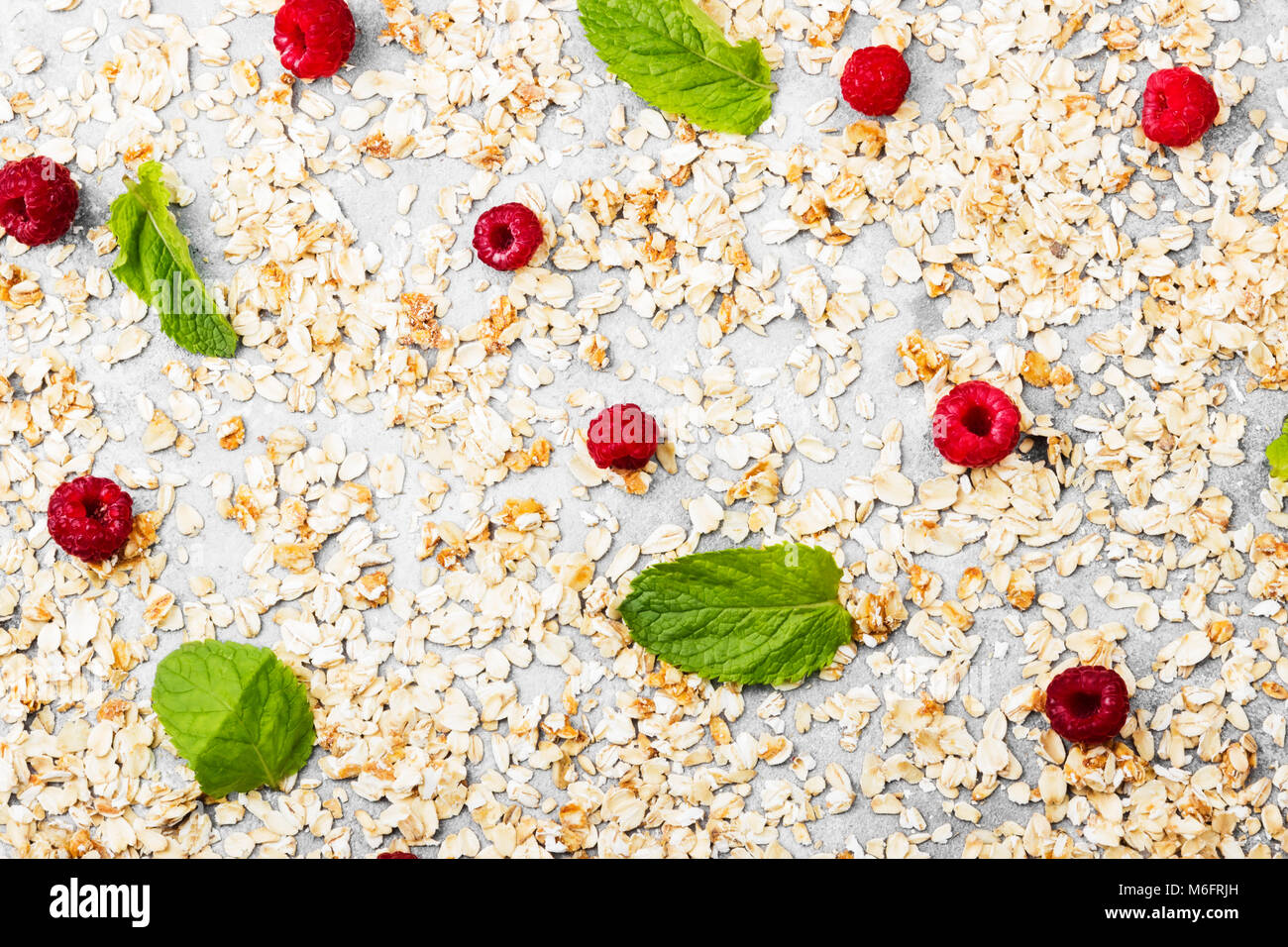 Glanola with raspberry and mint on a gray background. Top view, copy ...