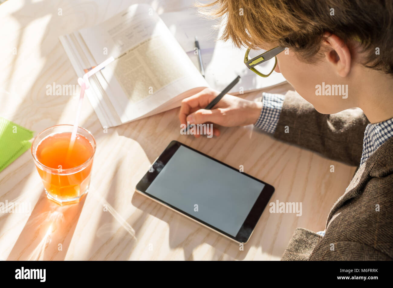 Male student in tweed jacket doing homework assignment at cafe during ...