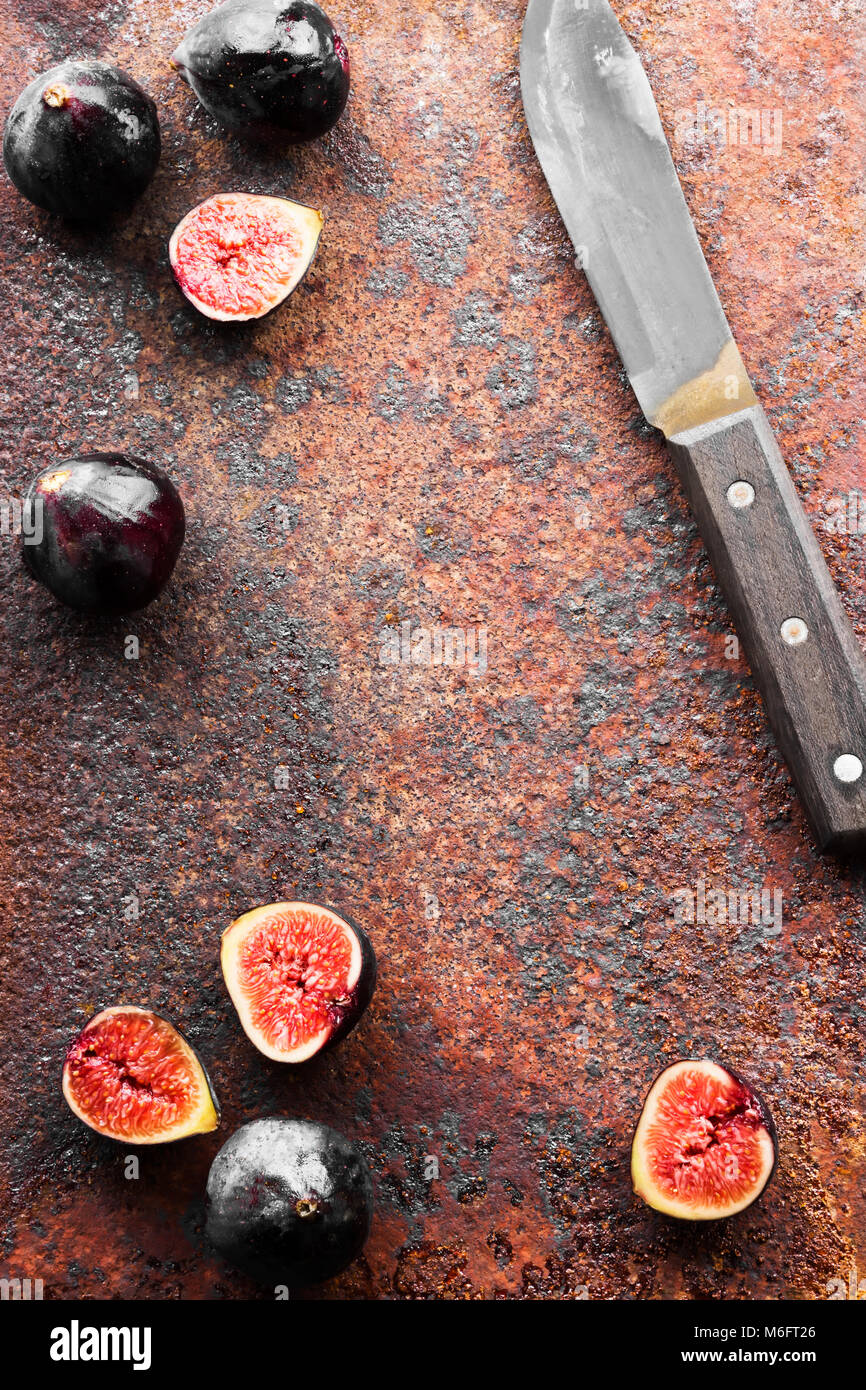 Fresh fig, knife with wooden handle on a rusty background. Top view ...