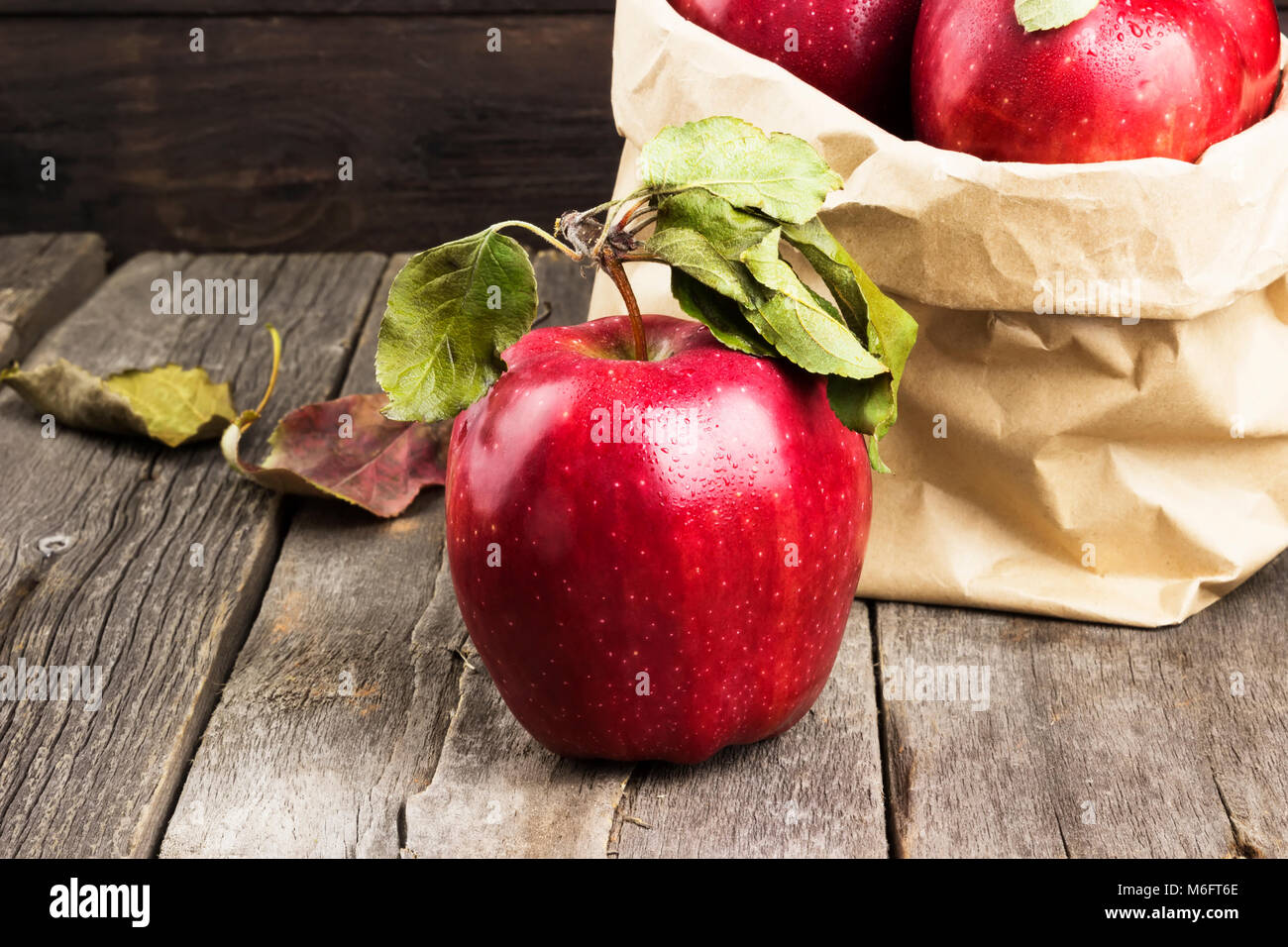 Apples in paper package on a dark wooden background Stock Photo - Alamy