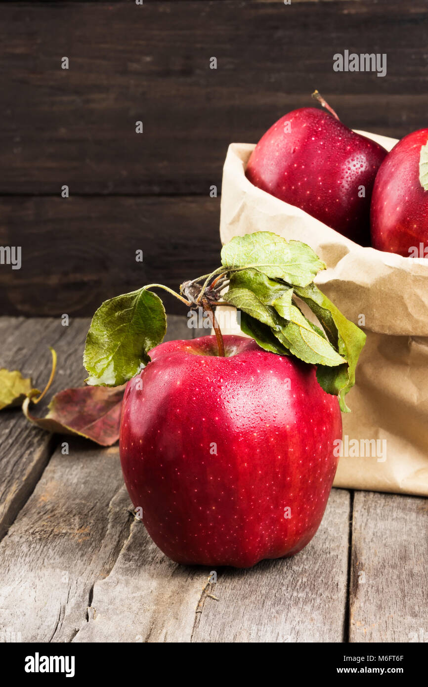 Apples in paper package on a dark wooden background Stock Photo - Alamy