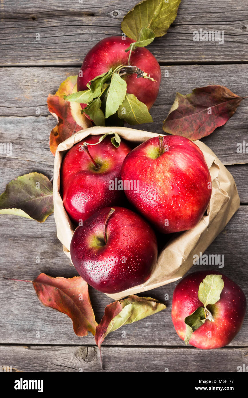 Apples in paper package on a dark wooden background. Top view. Food ...