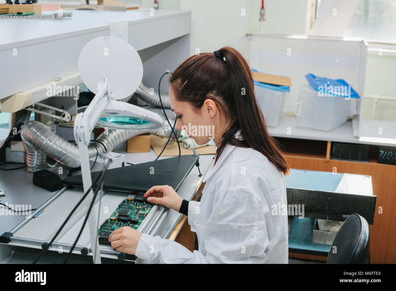 Beautiful female computer expert professional technician examining ...