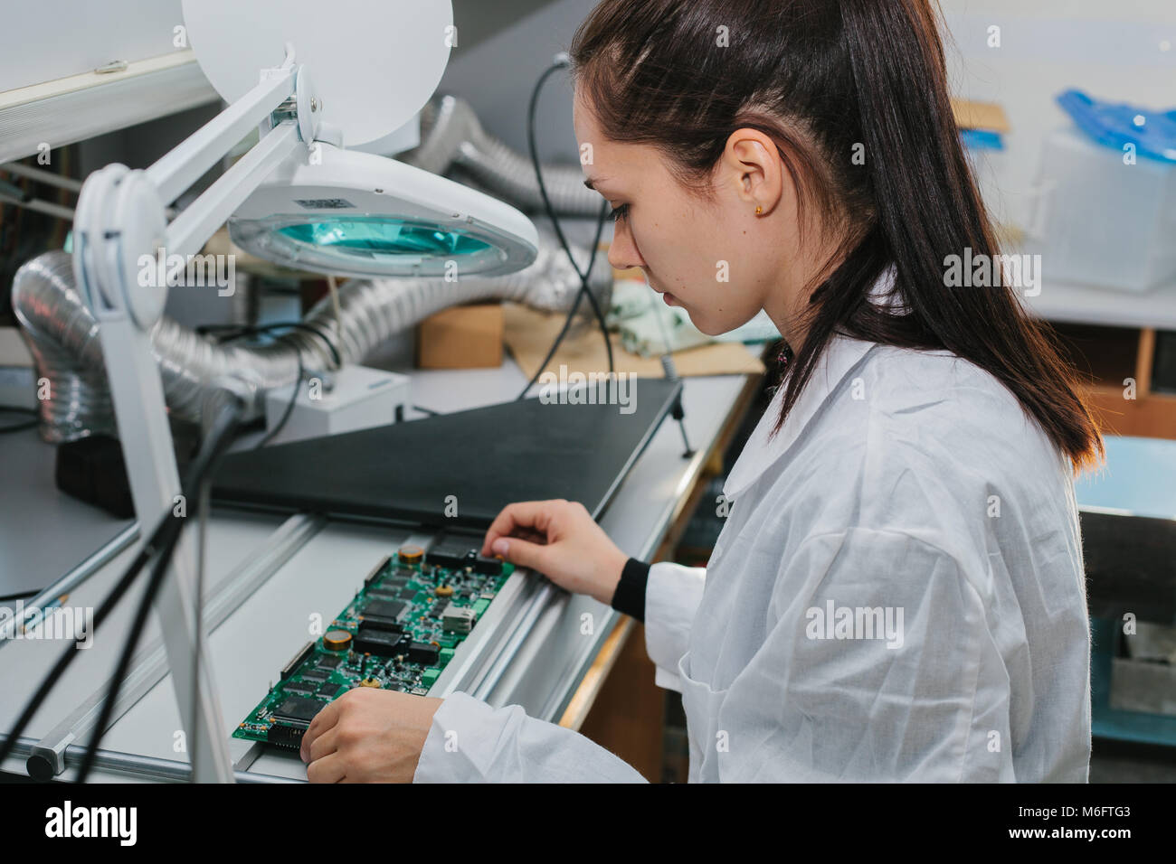 Beautiful female computer expert professional technician examining ...