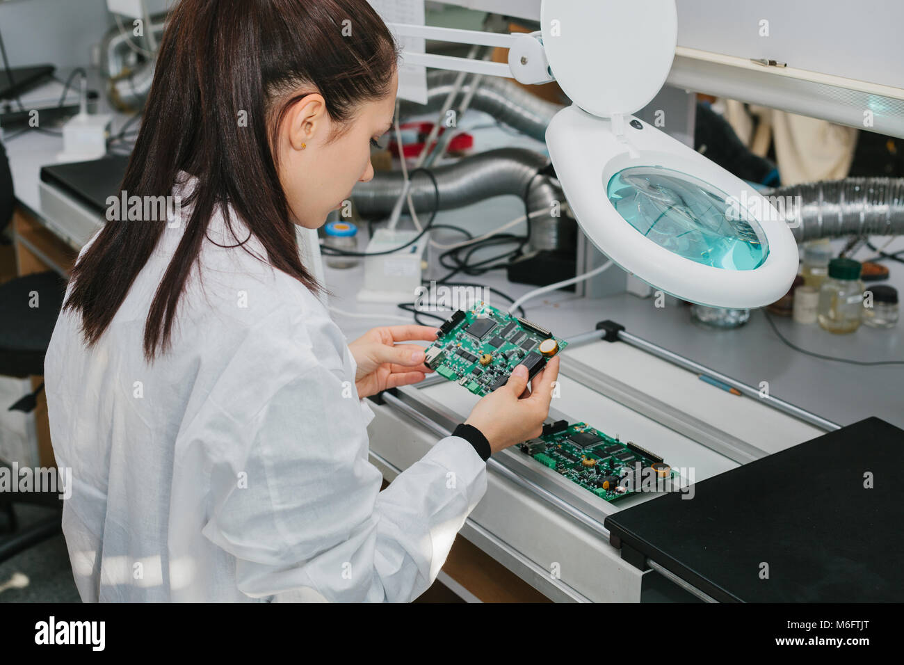 Beautiful female computer expert professional technician examining ...