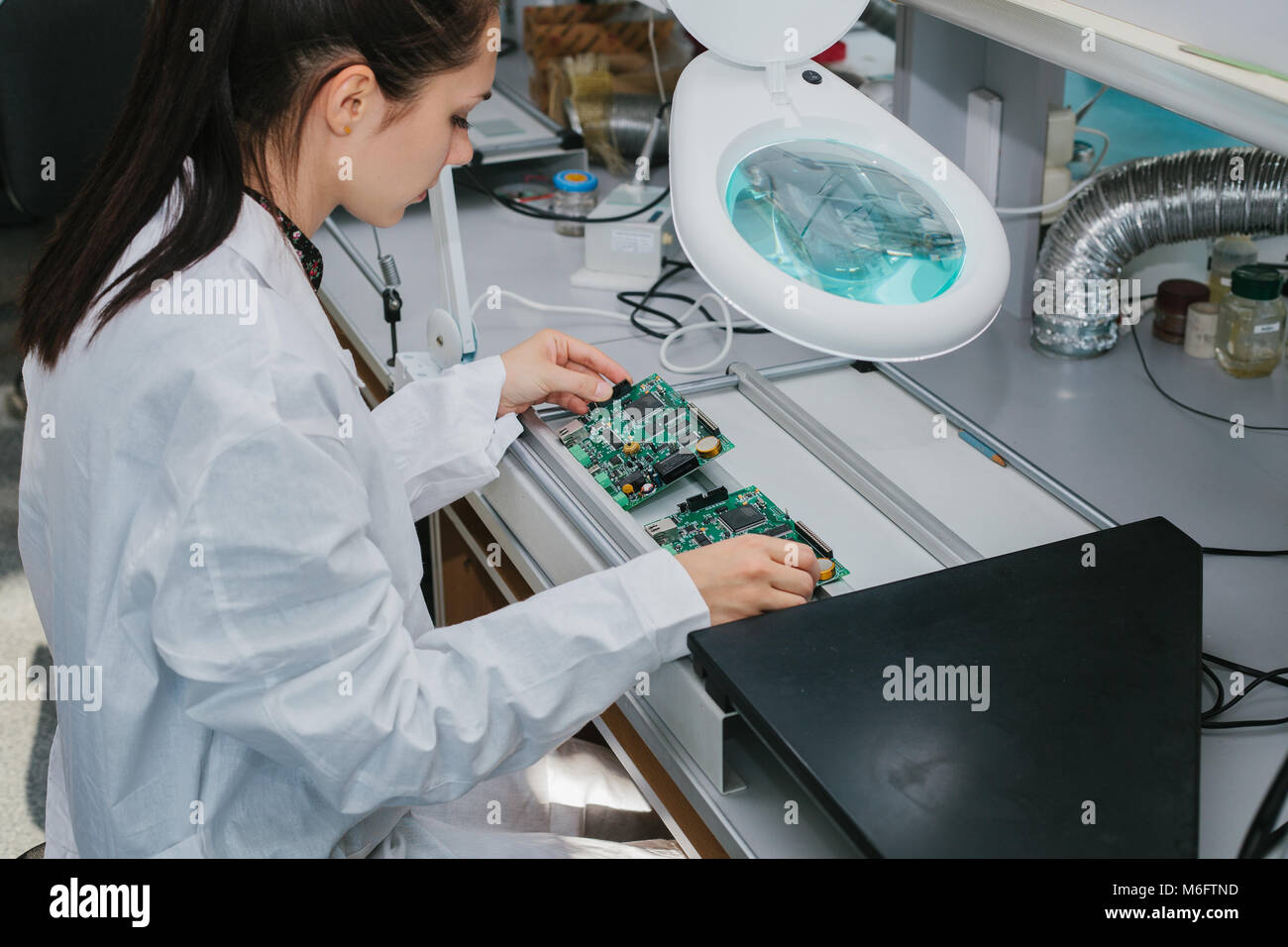 Beautiful female computer expert professional technician examining ...