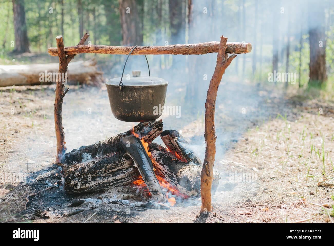 The fire near the camp. Cooking food on a fire. Journey Stock Photo - Alamy