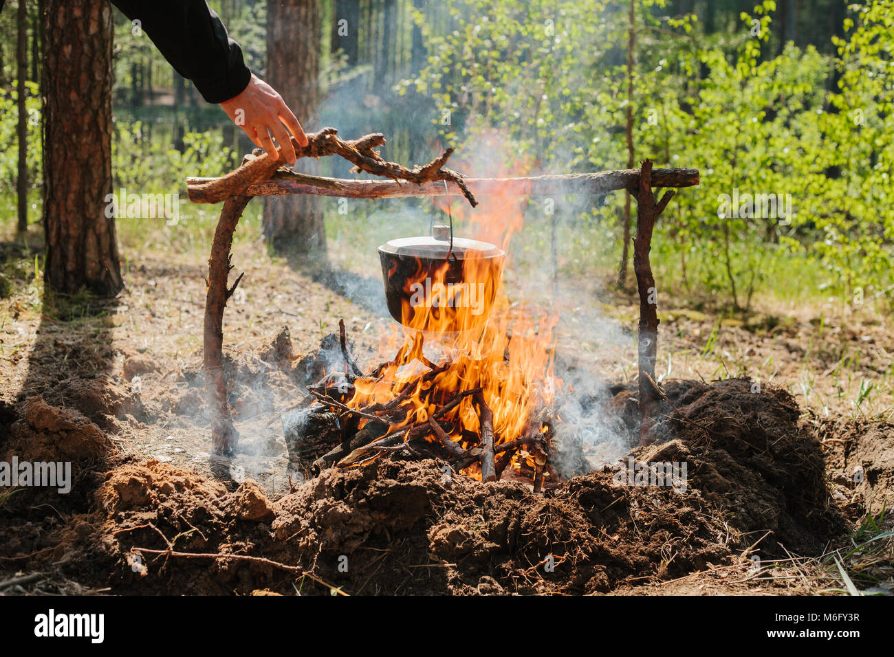 The fire near the camp. Cooking food on a fire. Journey into the wild concept Stock Photo - Alamy