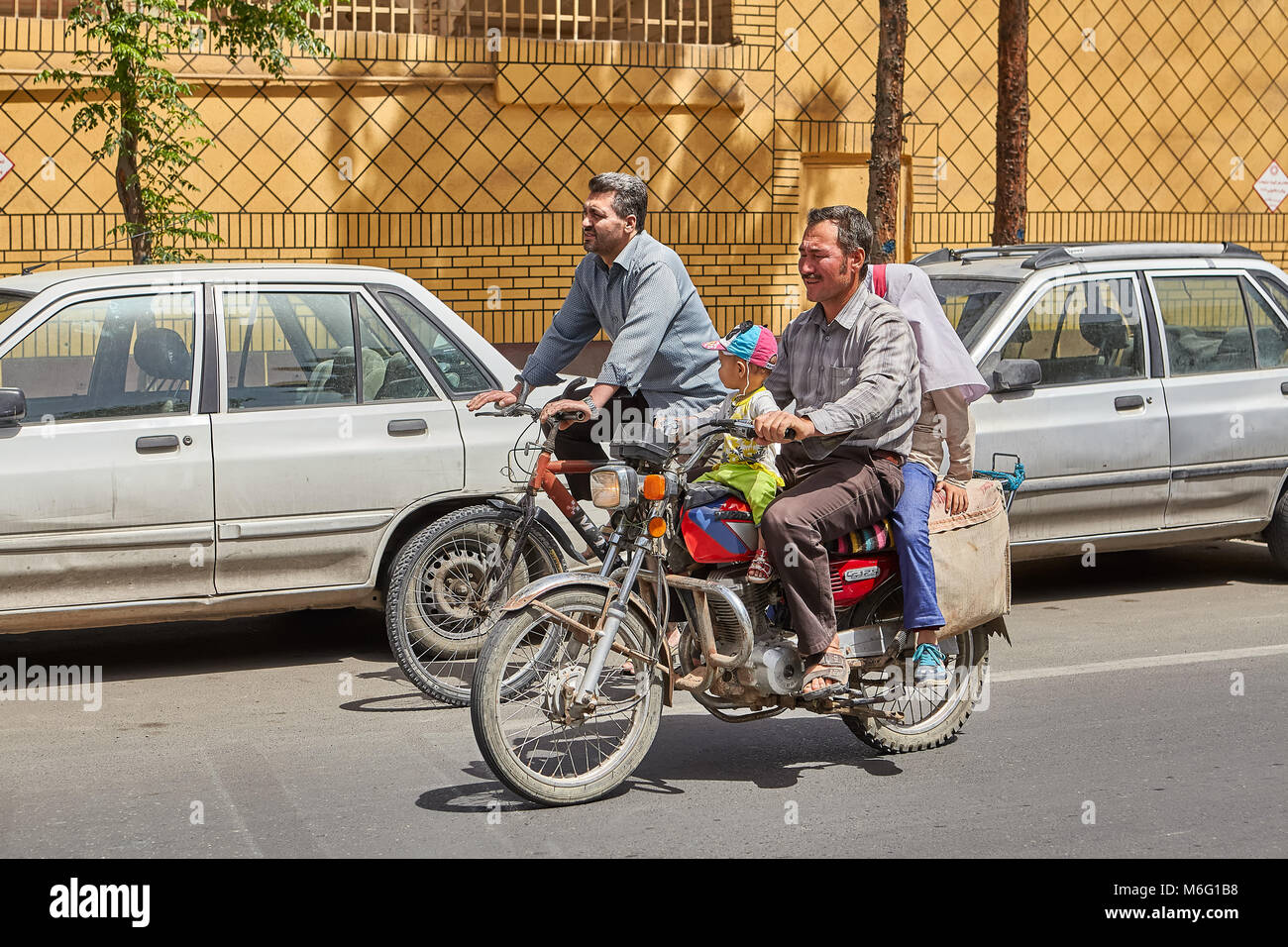 Kashan, Iran - April 27, 2017: Iranian man and his children are riding ...