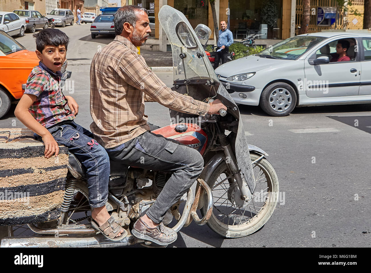 Kashan, Iran - April 27, 2017: Iranian man with his son is riding a ...
