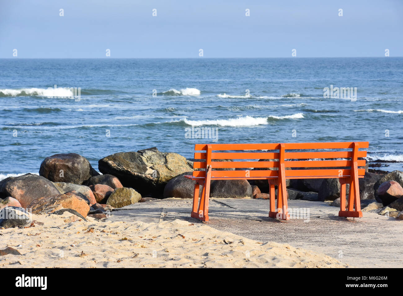 A colorful red bench on the beach of Swakopmund Namibia Southern Africa ...