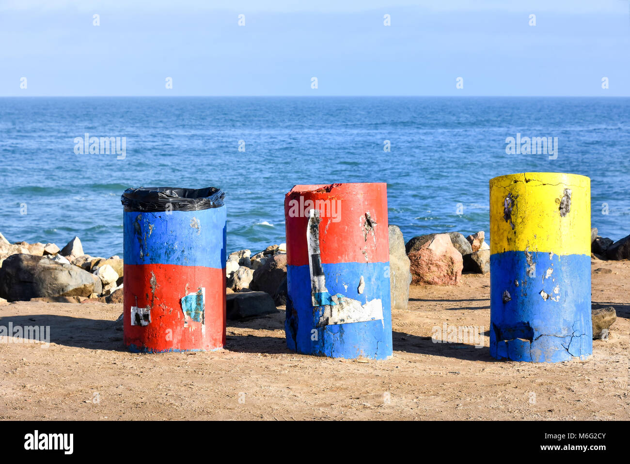 Colorful blue red and yellow trash cans near the beach of Swakopmund ...