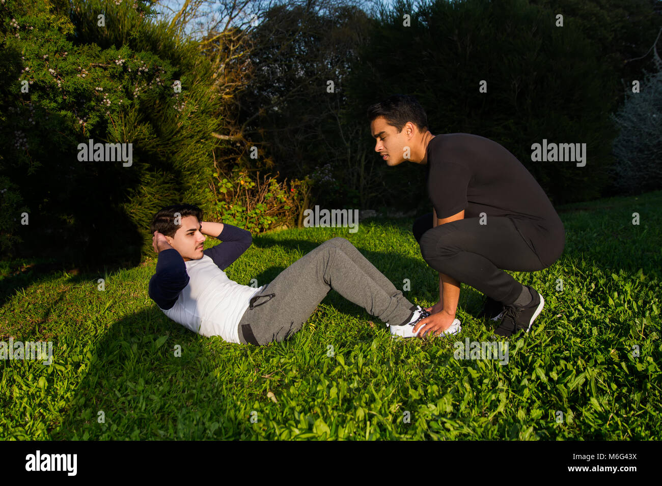 two young man making exercise, making push ups in a city garden Stock ...