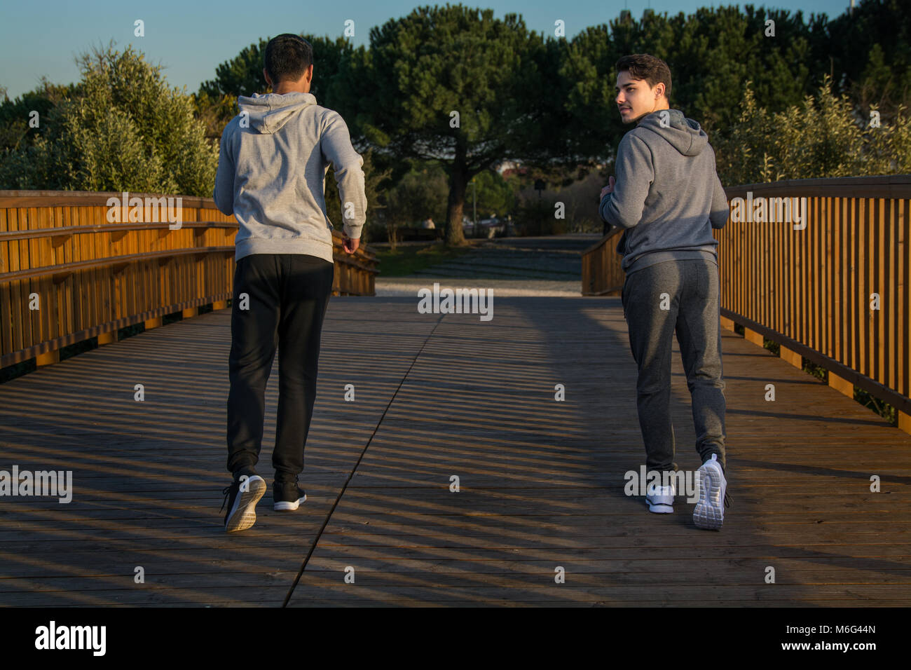 two friends in sport clothes runing in a city park Stock Photo - Alamy