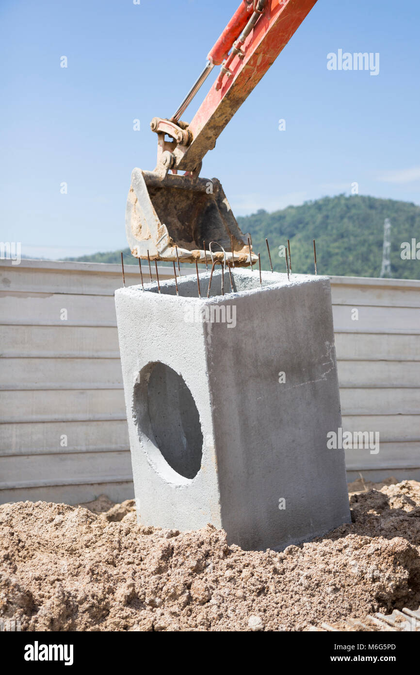 Excavator lift a manhole at construction site Stock Photo - Alamy