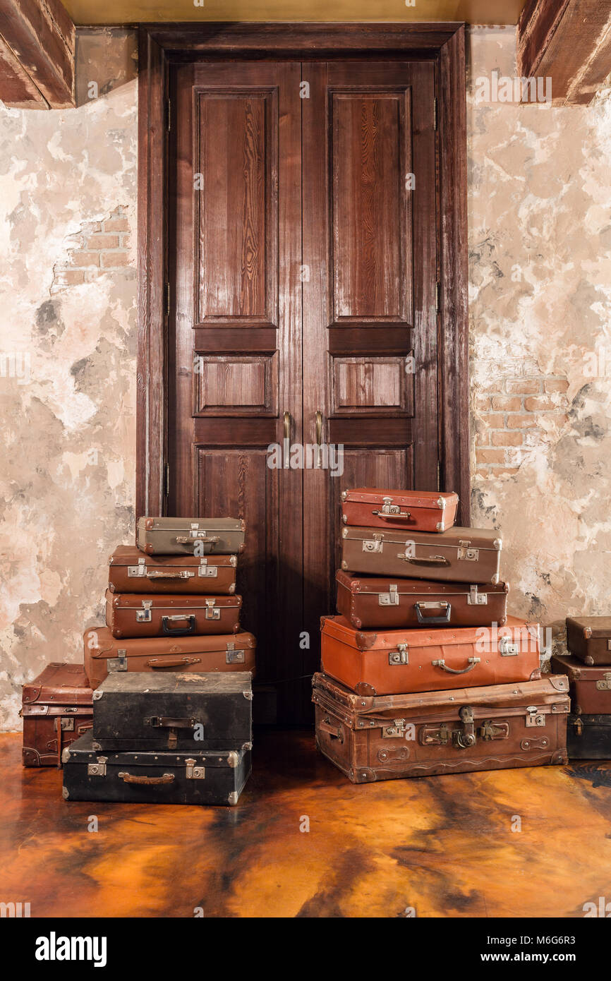 The door and the bag. Vintage used travel suitcases. Many old vintage ...