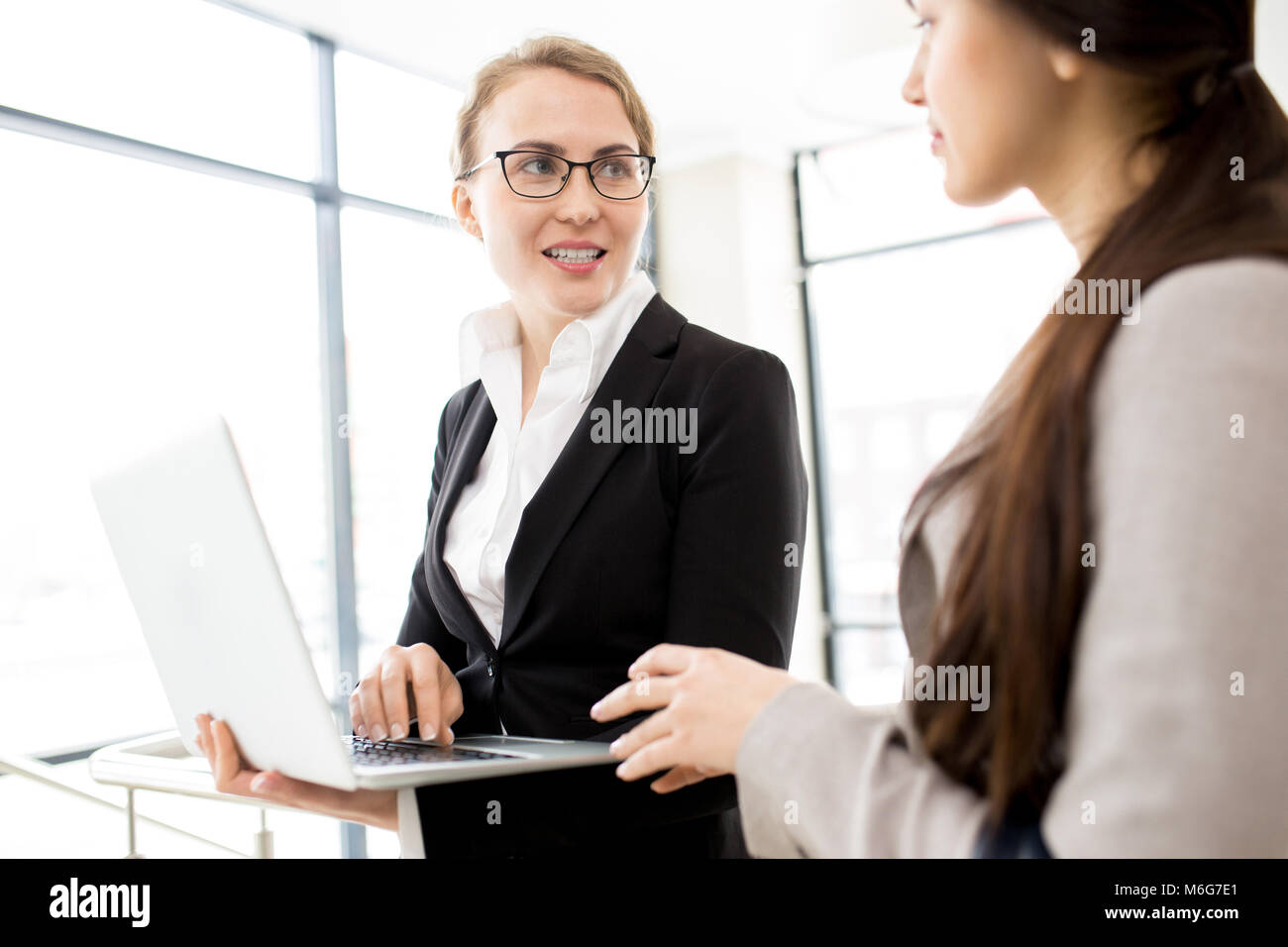 Pretty Colleagues at Spacious Office Lobby Stock Photo - Alamy