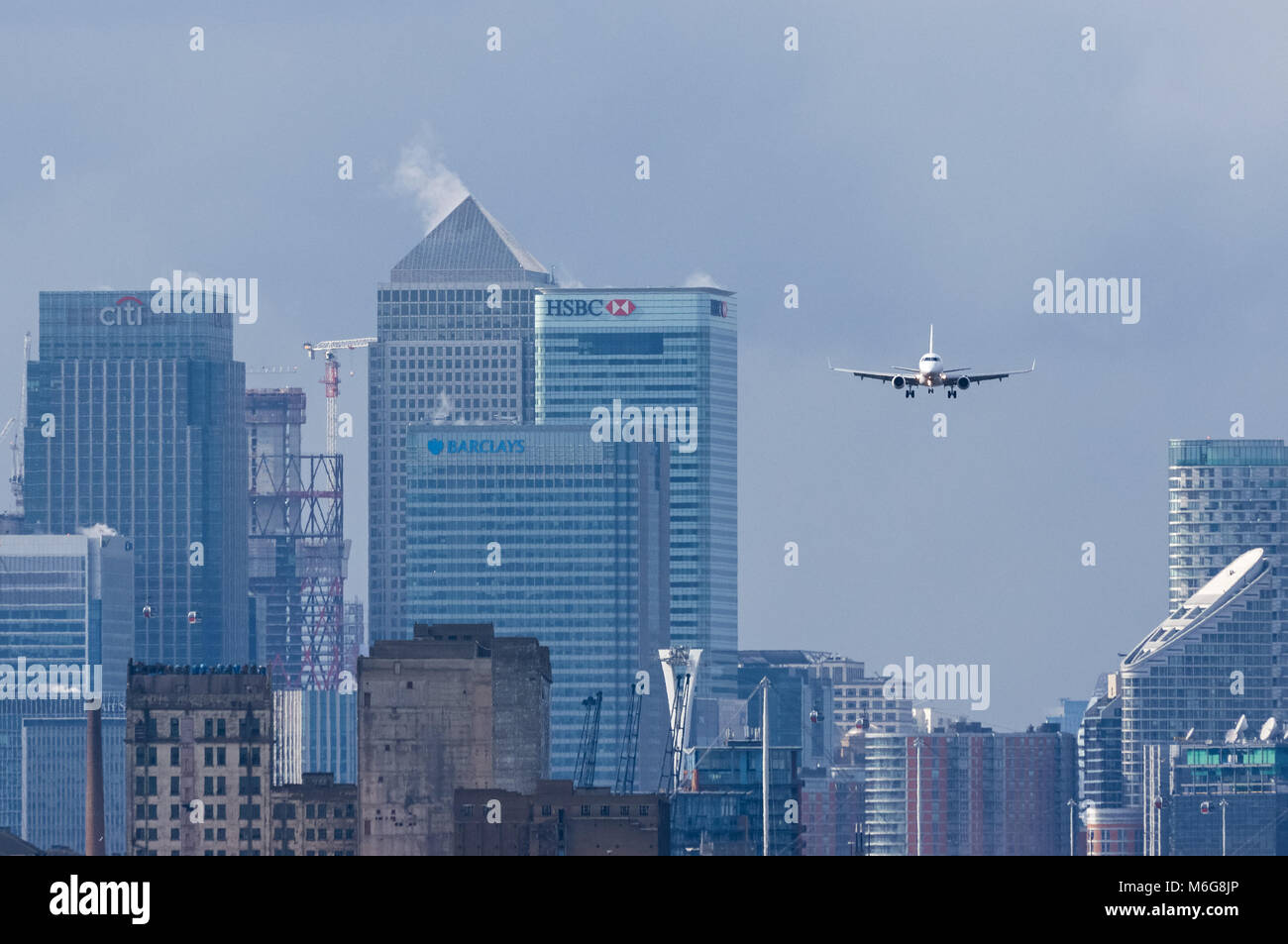 Airliner landing at London City Airport with Canary Wharf skyscrapers ...