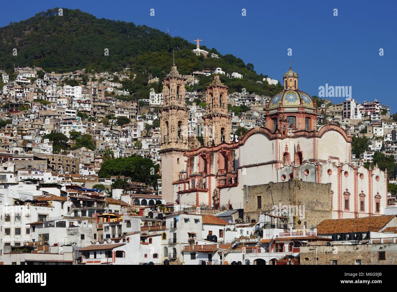 Daytime view of Taxco de Alarcon, Mexico with Christ ststue and Church ...