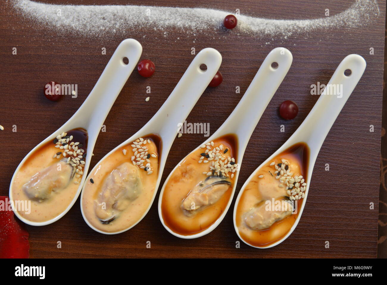 party appetizers. Four white spoons with mussels Spanish Tapas ...