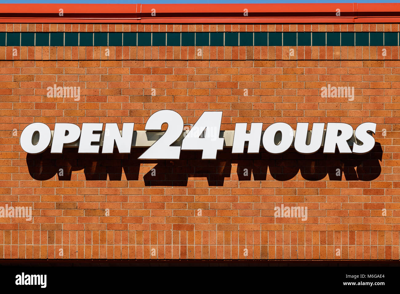 White Open 24 Hours signage against brick background I Stock Photo - Alamy