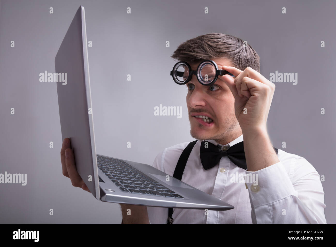 Weird Man Looking At Laptop On Grey Background Stock Photo - Alamy