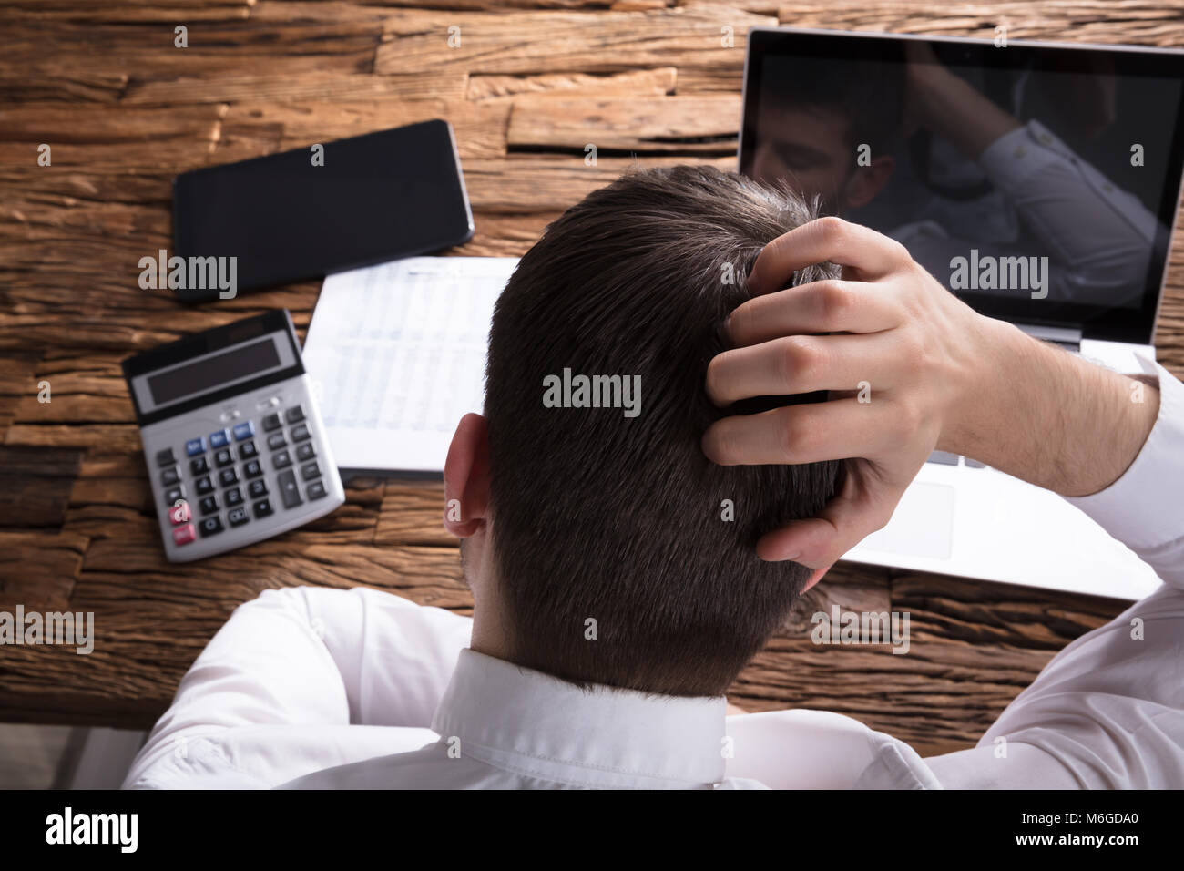 Rear View Of A Stressed Businessman Scratching Head In Front Of Laptop ...