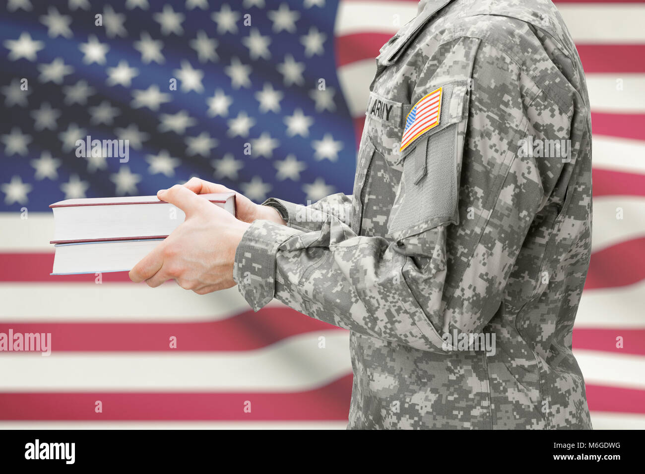 U.S. army soldier holding books in his hands Stock Photo - Alamy