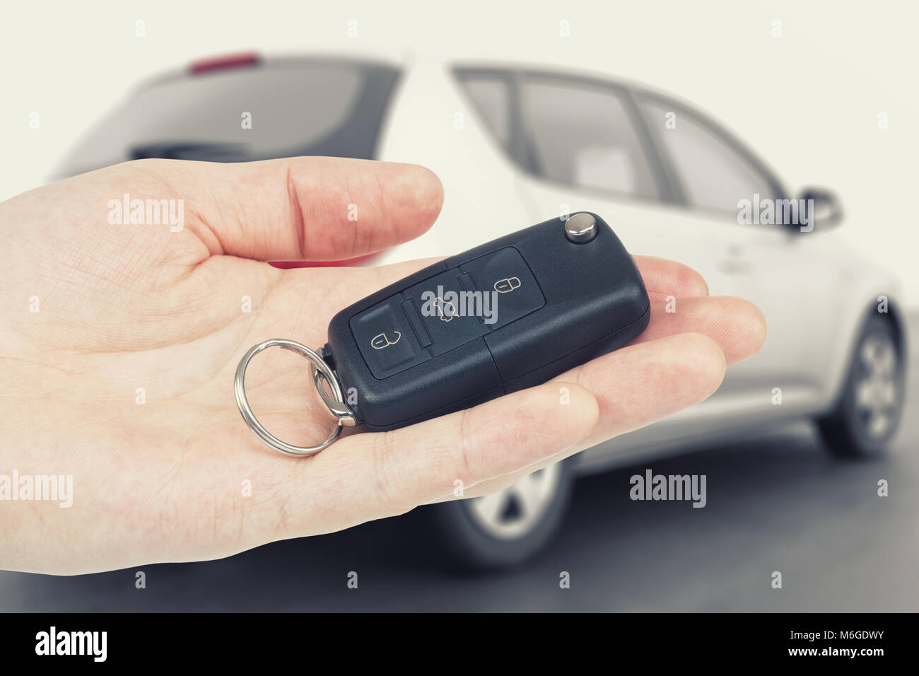 Car keys on a palm with car on background Stock Photo - Alamy