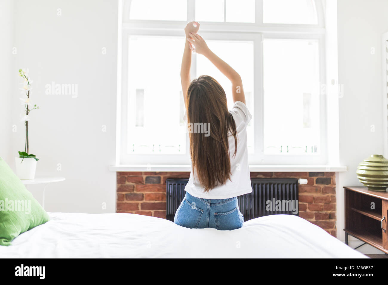 Woman stretching in bed after wake up, back view Stock Photo - Alamy