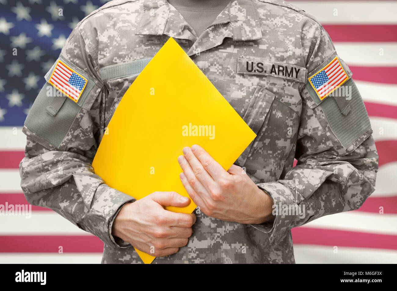 U.S. army soldier holding yellow folder in hands Stock Photo - Alamy