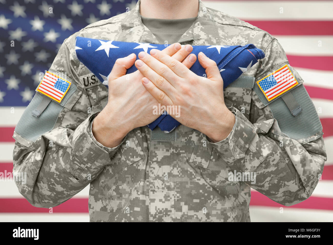 US Army soldier holding folded USA flag before his chest Stock Photo ...