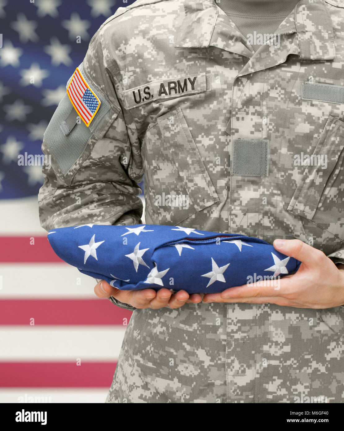 U.S. Army soldier holding folded USA flag before his chest Stock Photo ...